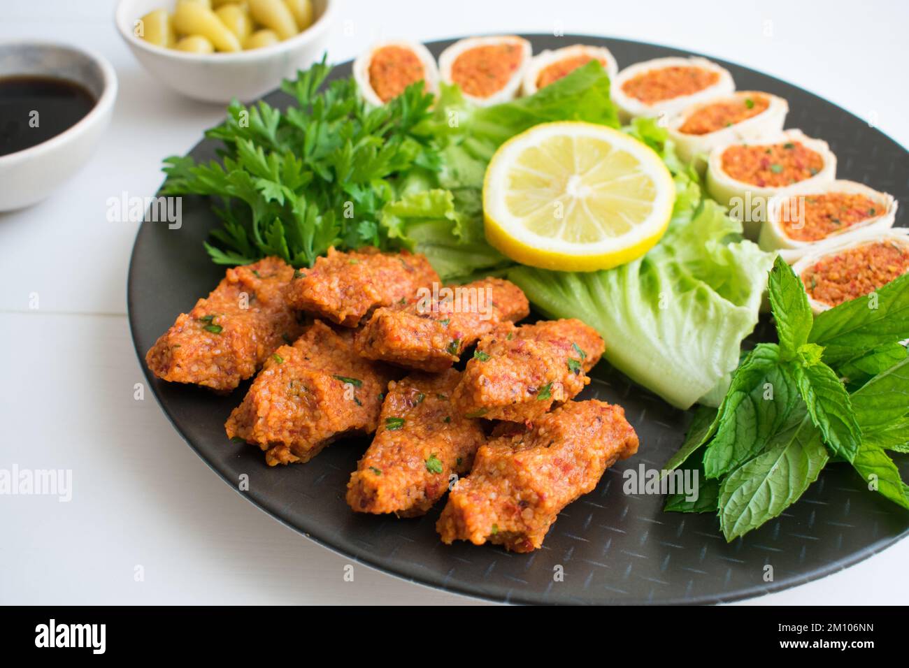 Turkish "cig kofte”, close-up Turkish meatballs cut into lettuce ...