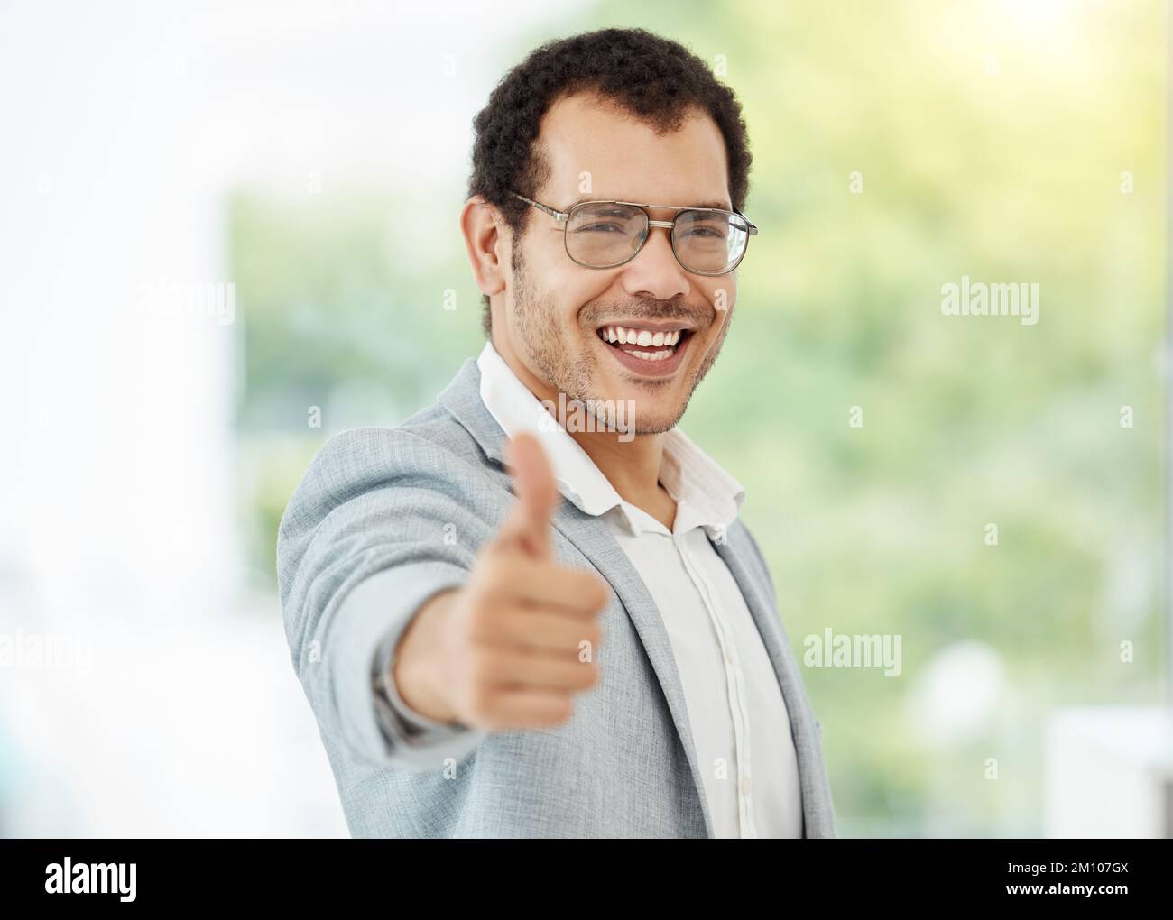 Im rooting for you. Portrait of a young businessman showing thumbs up ...