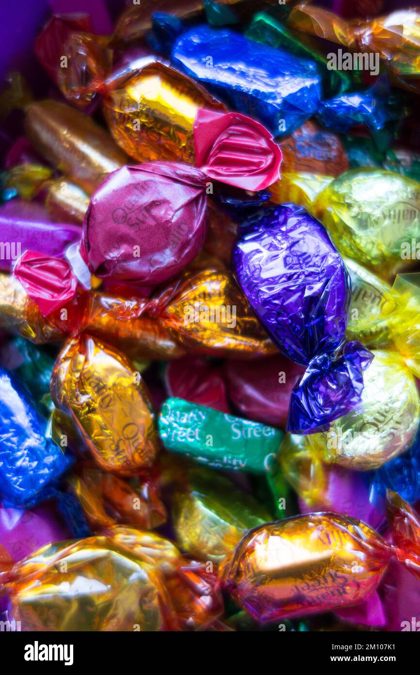 Closeup of Nestlé Quality Street sweets, chocolates and coloured foil ...