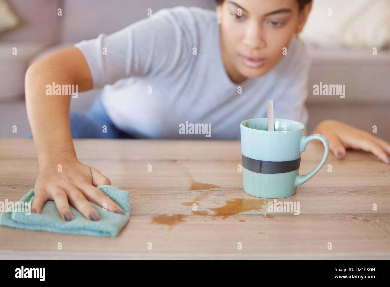 Cleaning surface, coffee spill and woman wipe furniture, coffee table ...