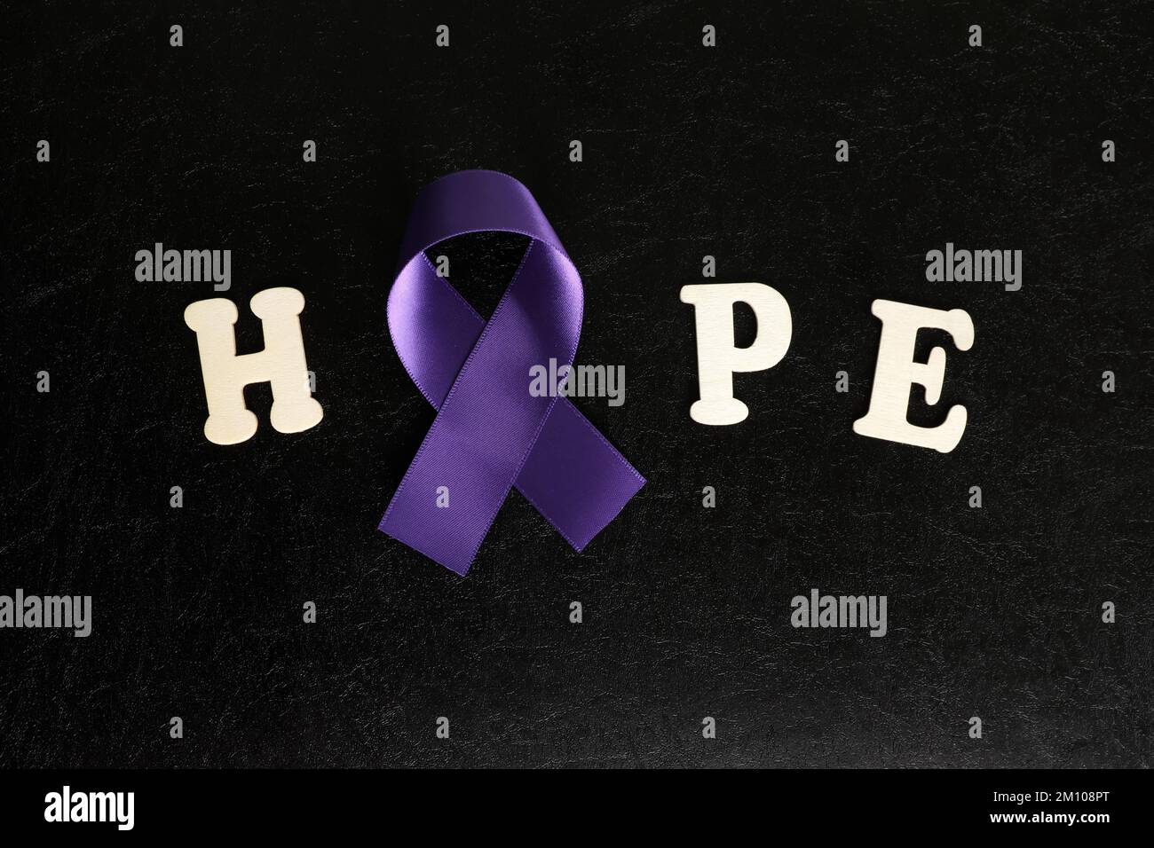 Purple or violet ribbon color on dark black background with word hope ...