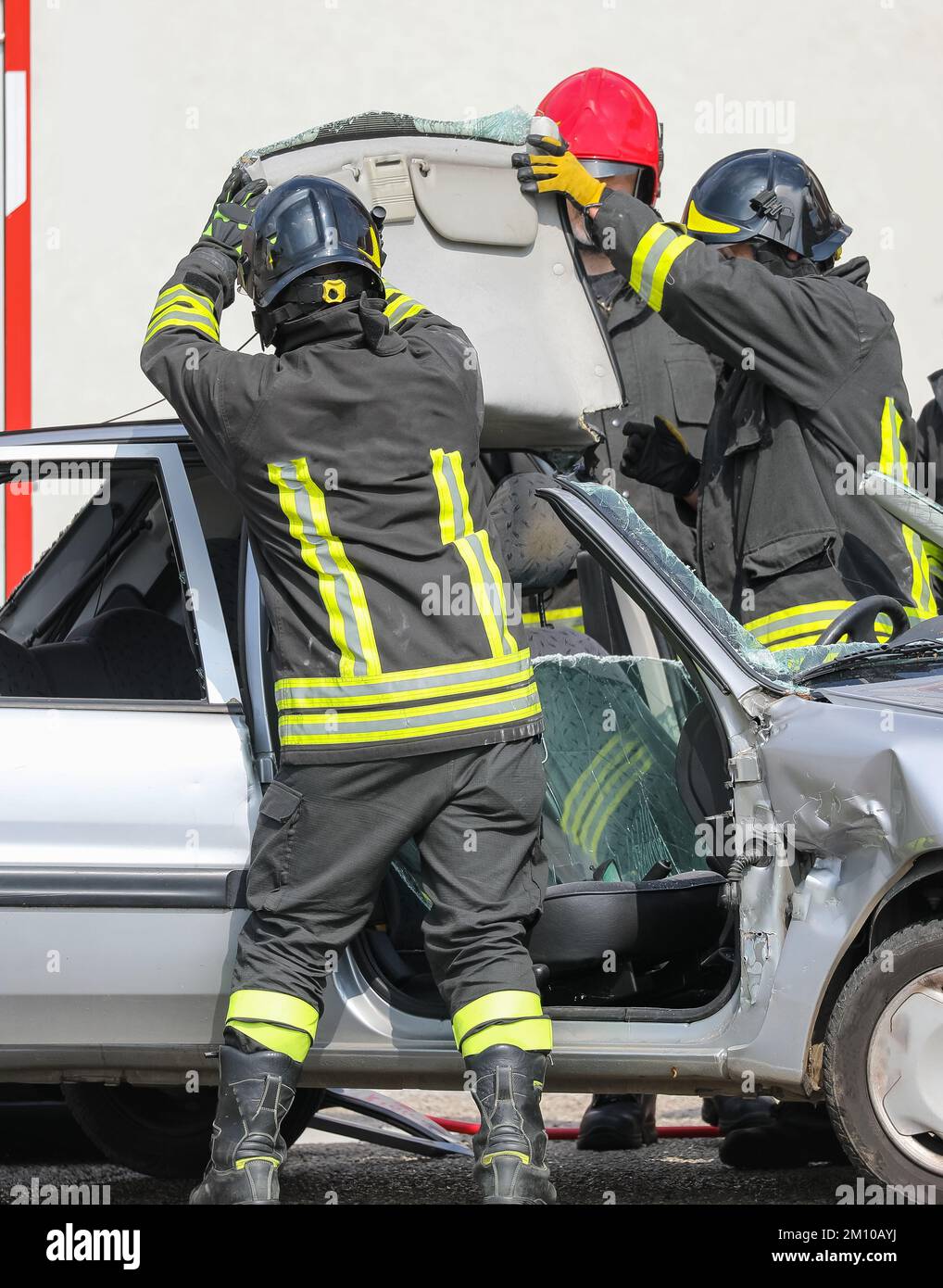 firefighters remove the roof of the crashed car after the accident ...