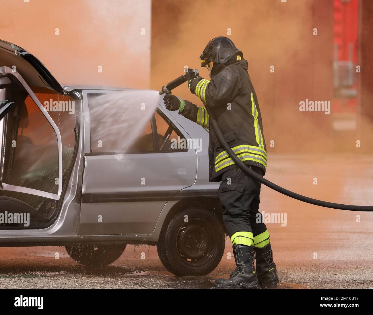 firefighters extinguish the fire of the crashed car after the traffic ...