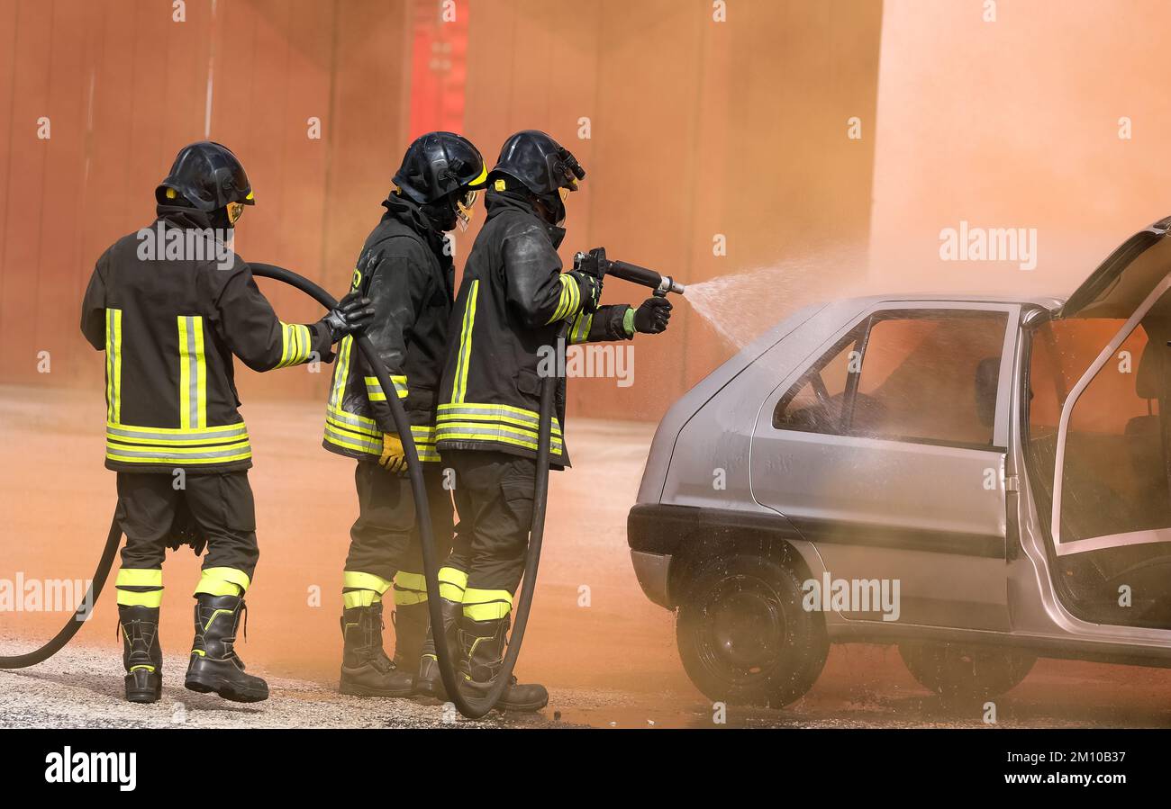 firefighters extinguish the fire of the crashed car after the traffic ...