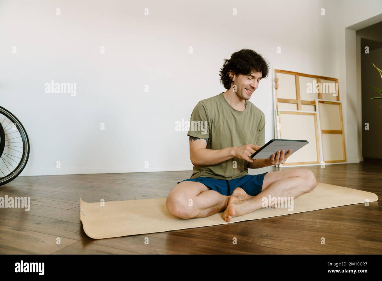 White man using tablet computer during yoga practice at home Stock ...