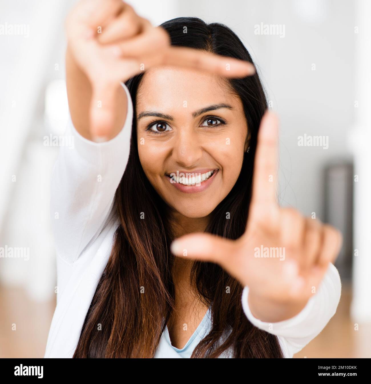 Frame up for the perfect shot. a young indian woman framing her face with her fingers Stock ...