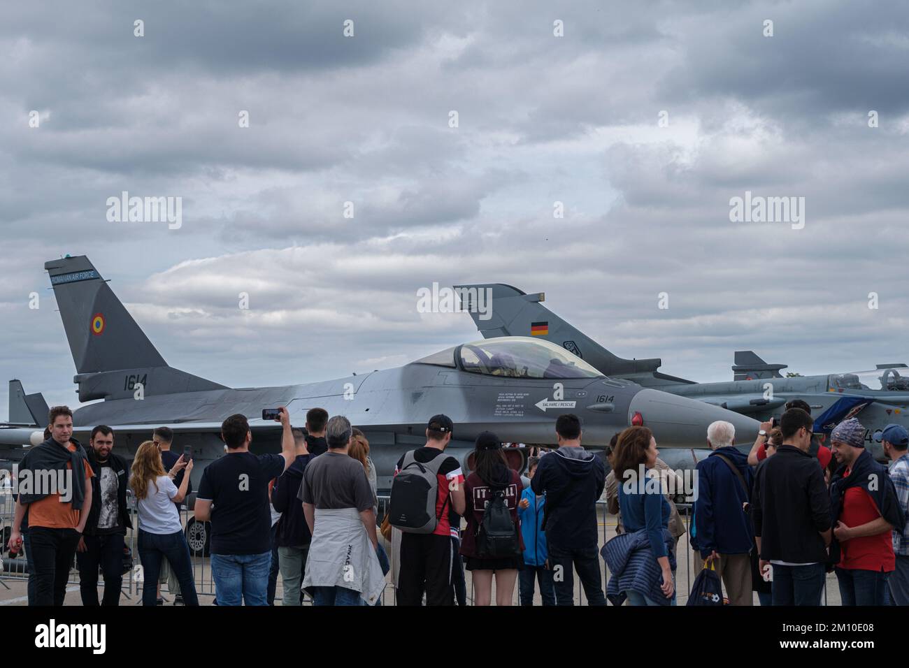A closeup shot of people gathered around a General Dynamics F-16 ...