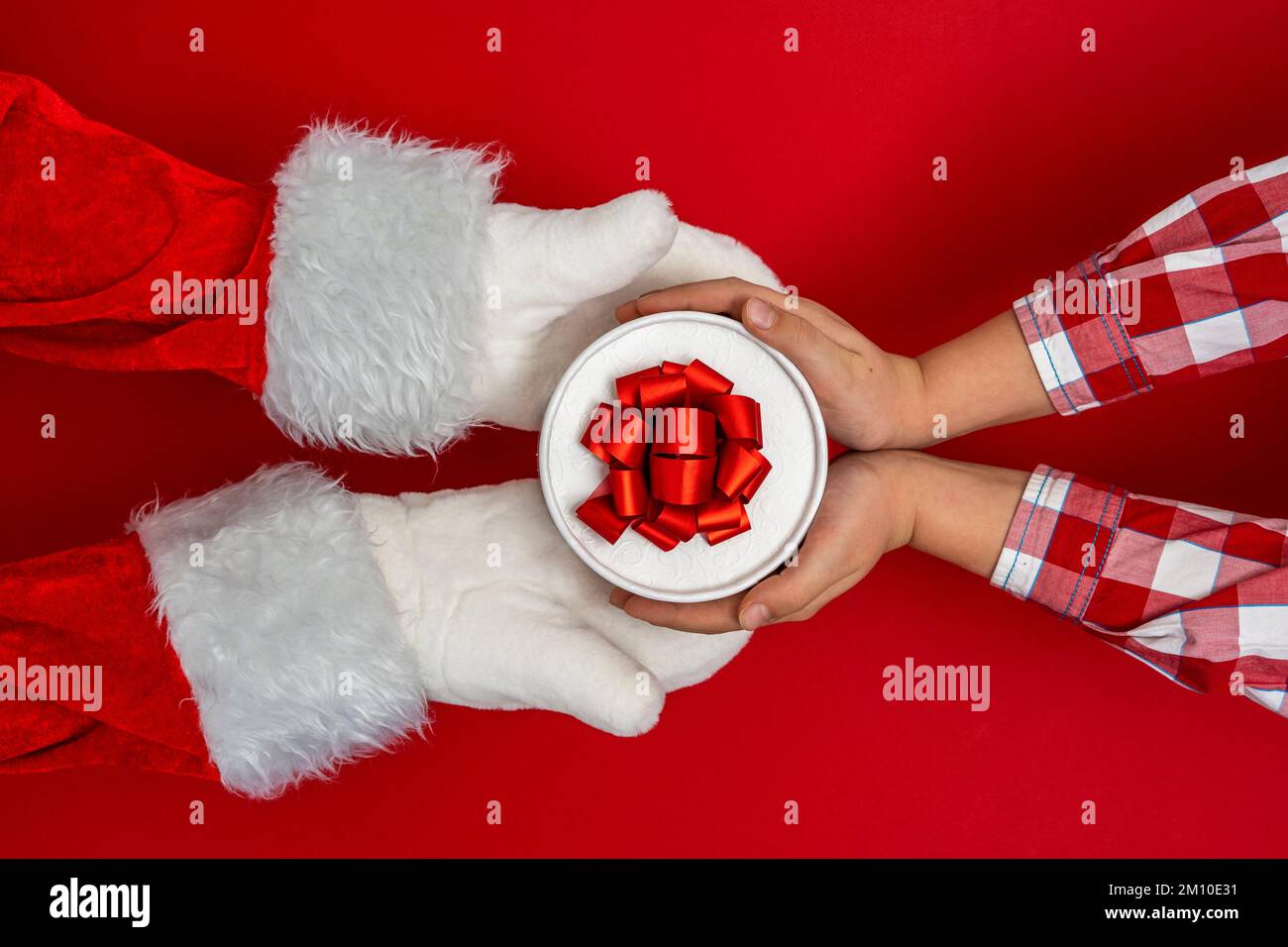 Santa's hands give gifts to children at Christmas. red background Stock ...