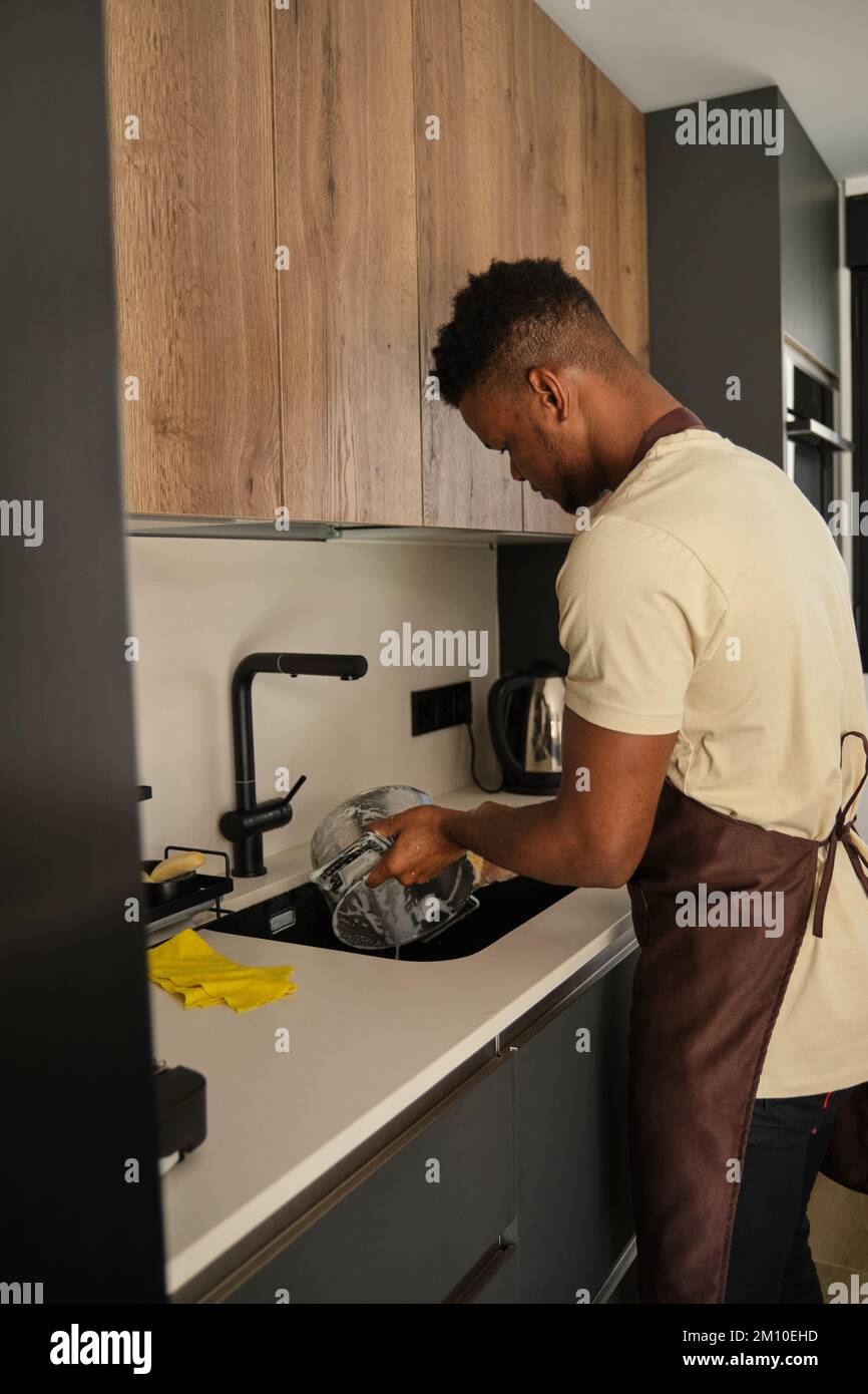 Young african man hand washing stainless steel pot with soap Stock ...