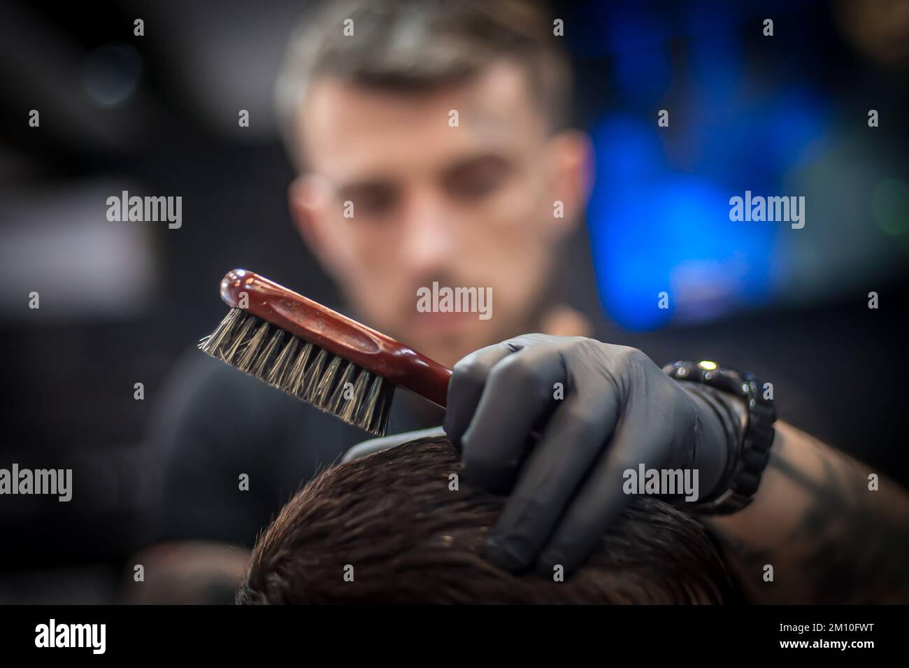 Modern urban hairdresser cut and adjusts the hairstyle in professional ...