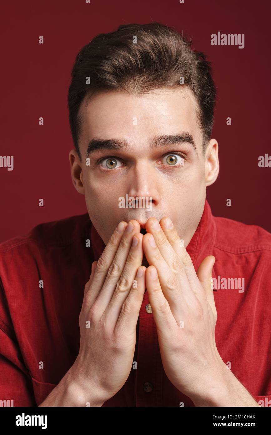 Young white man wearing shirt expressing surprise at camera isolated ...