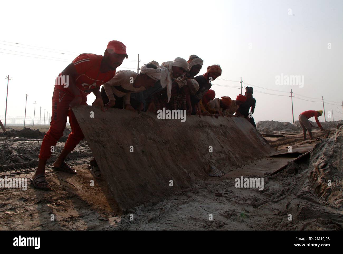 Prayagraj, India. 09/12/2022, Indian Labourers lay iron plates as they ...