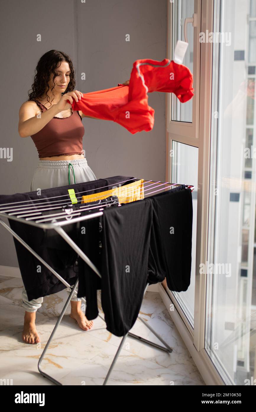 Young woman hanging up laundry Stock Photo - Alamy