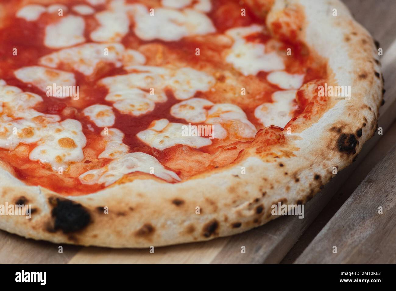 Hot pizza Margherita ready to eat with tomato sauce and mozzarella on a ...