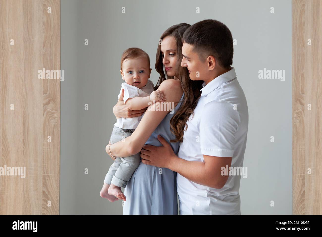Happy young family together. Beautiful Mother and father holding child ...
