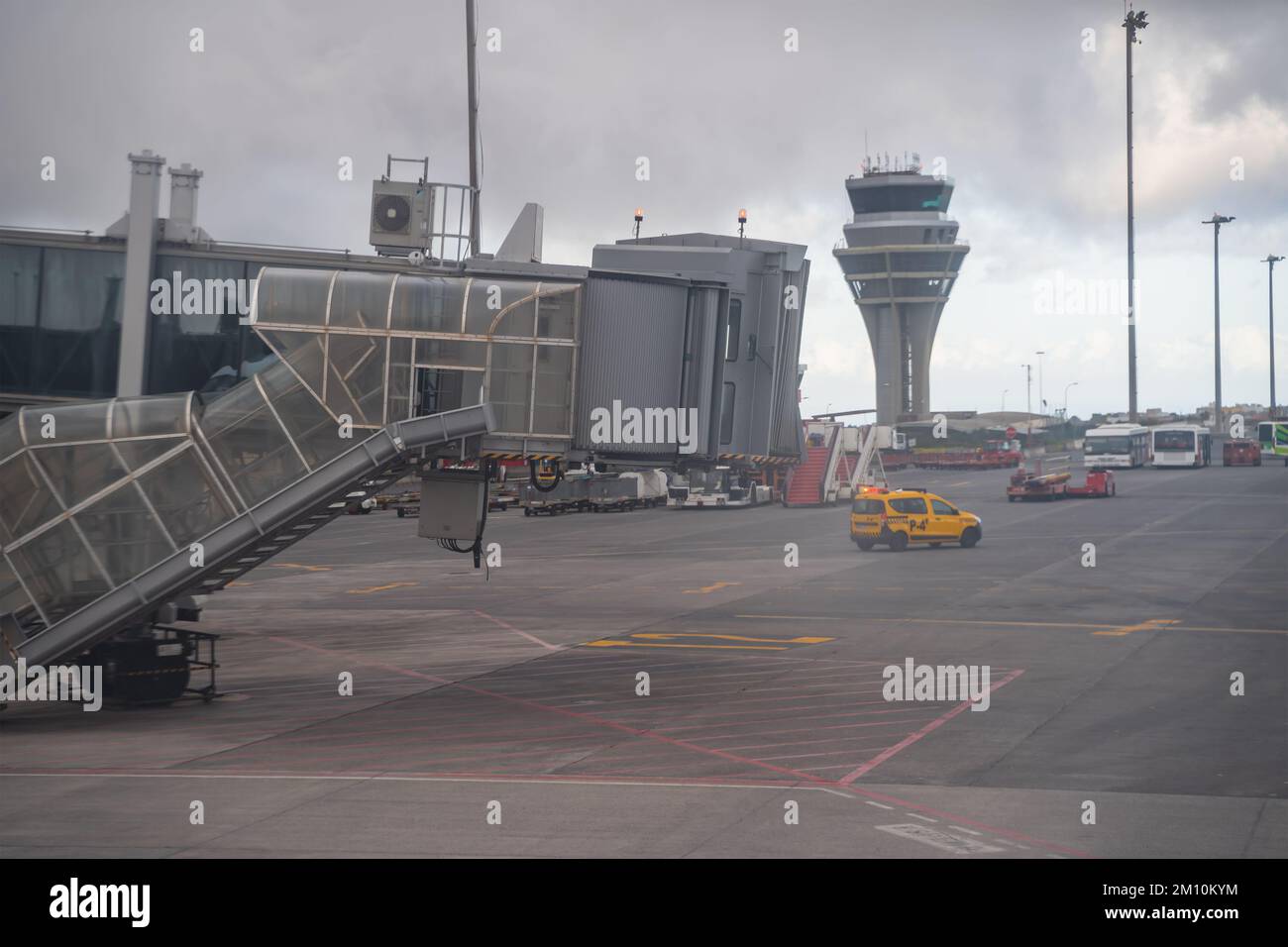 Access gangway to the aircraft and its control tower on a gray and dark ...