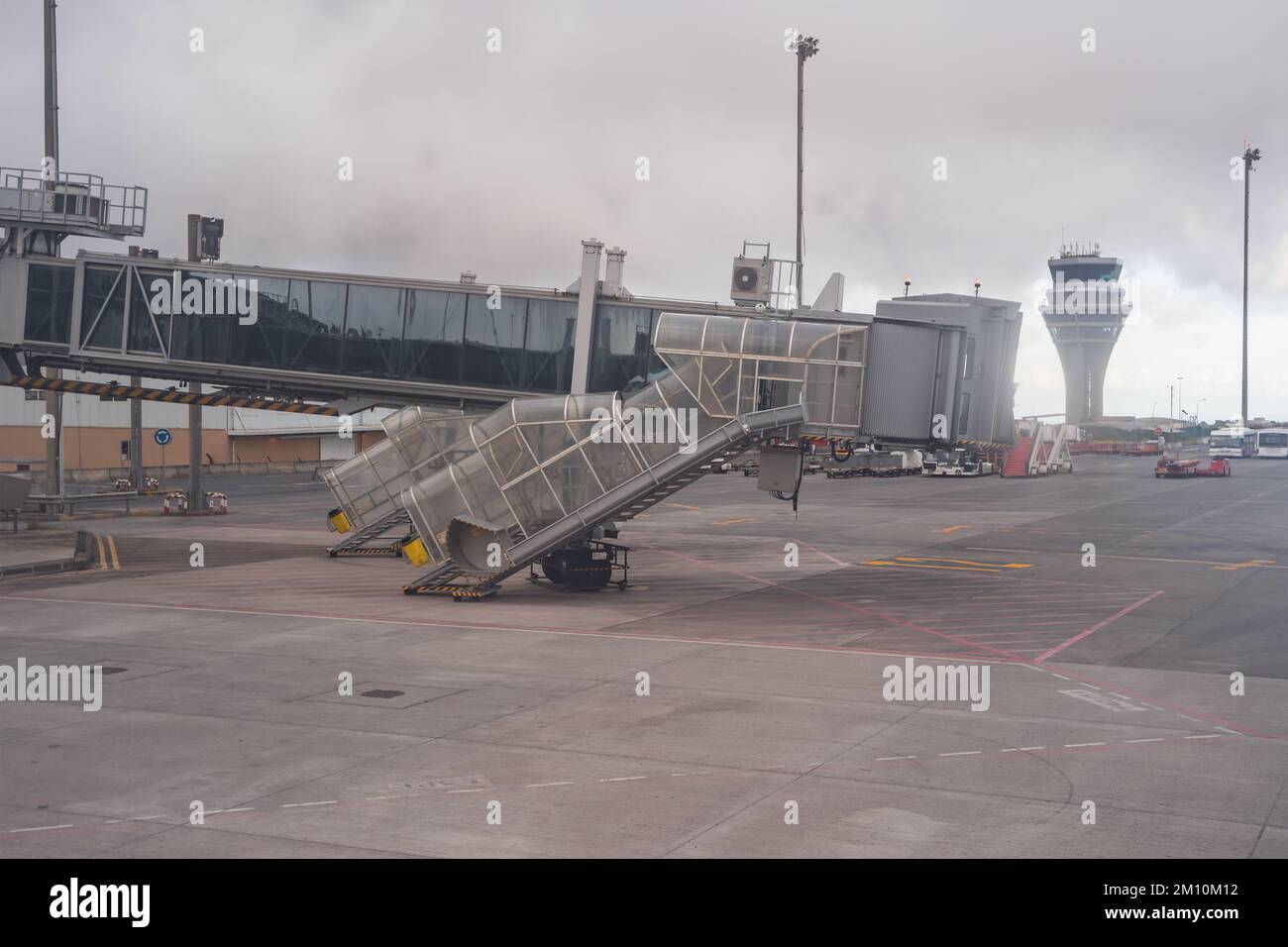 Access gangway to the aircraft and its control tower on a gray and dark ...
