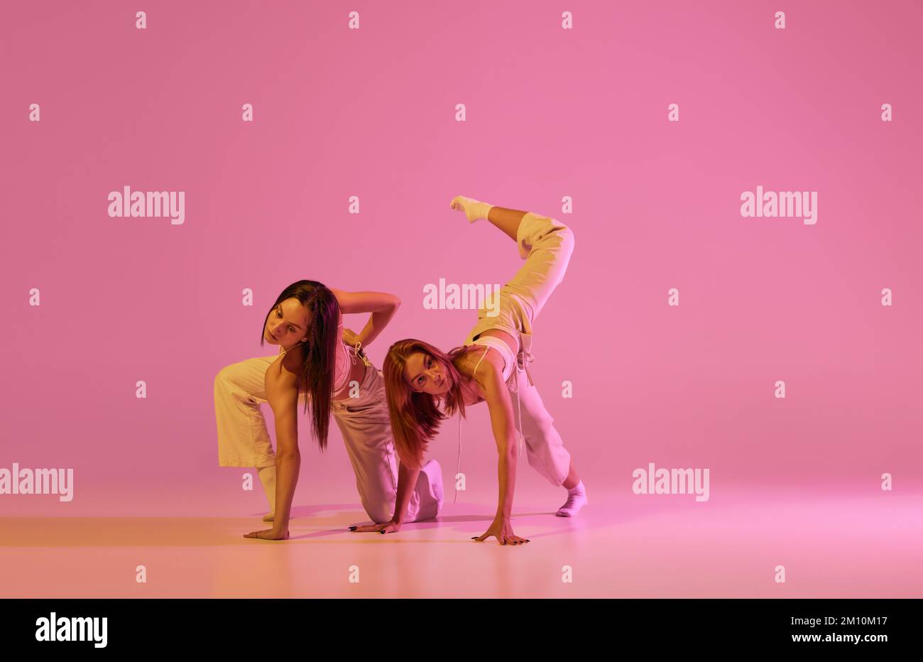 Modern dance art. Young girls, couple of dancers in sports style clothes dancing experimental ...