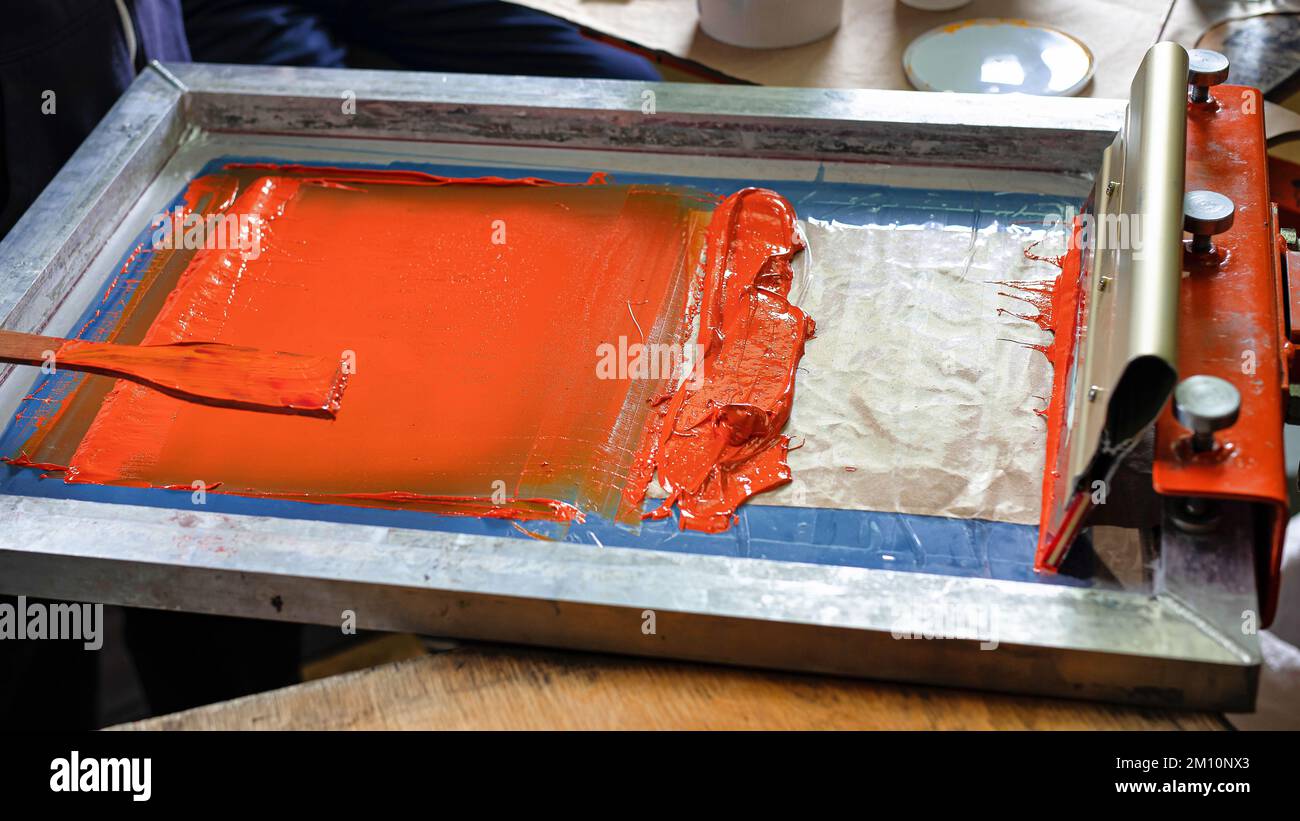 plastisol ink (paint) on a mesh screen frame. serigraphy production ...