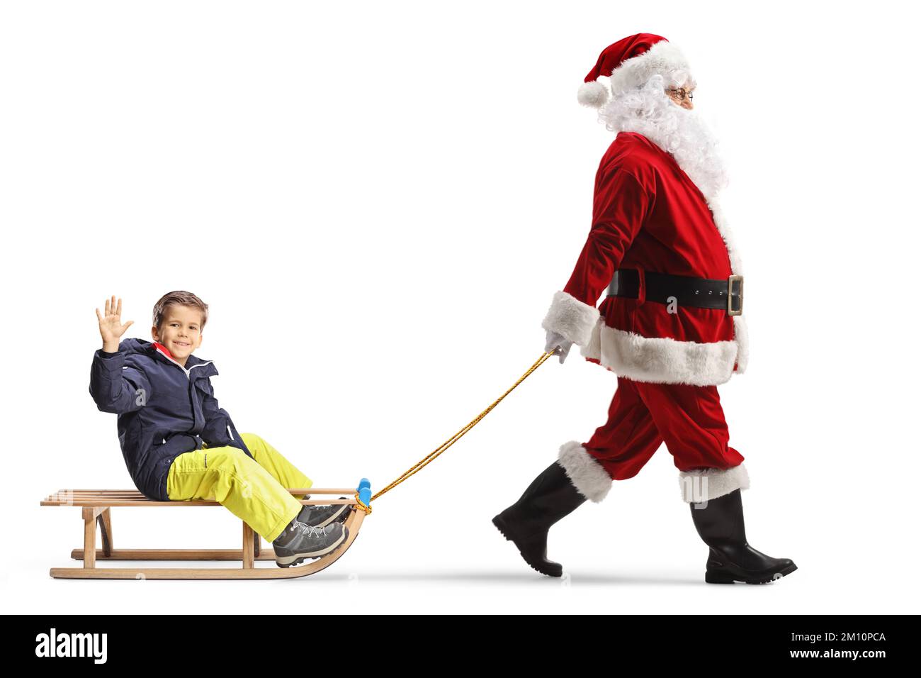 Full length profile shot of santa claus pulling a boy on a wooden ...