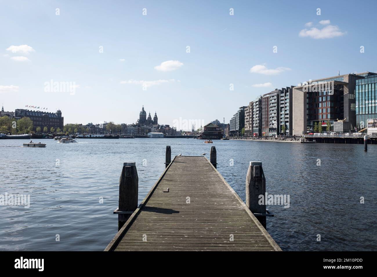 Looking along a long mooring pier at Oosterdok in Amsterdam, the ...