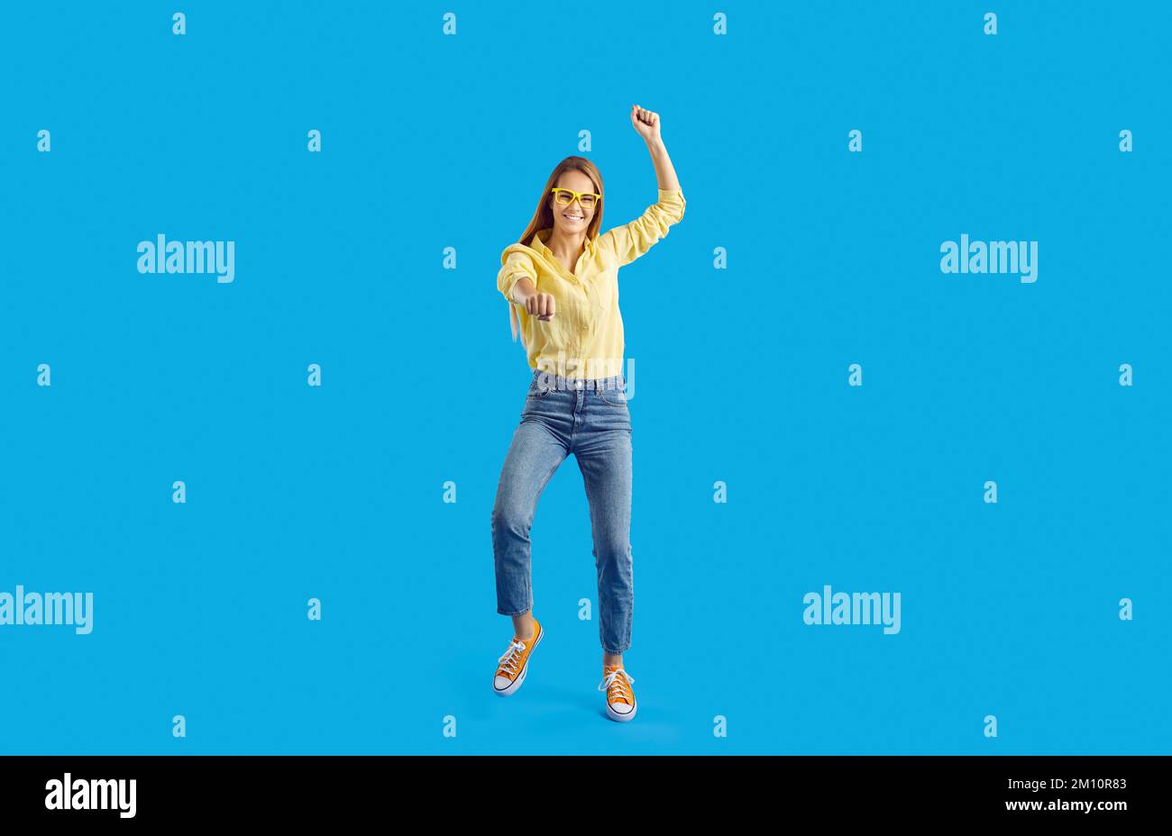 Happy young woman dancing feeling euphoric and celebrating success on ...