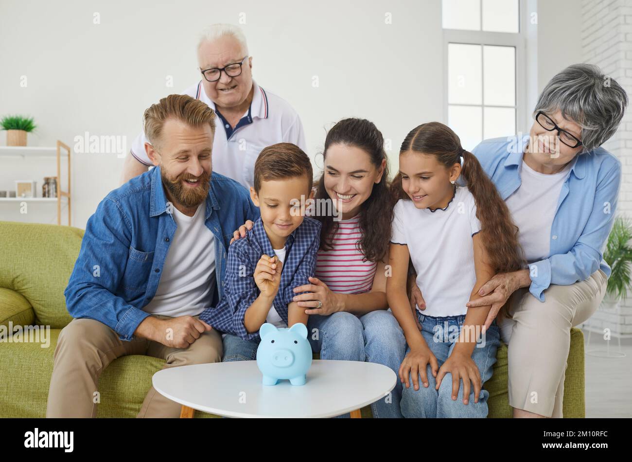 Joyful multi-generational family teaches little boy to collect money in ...