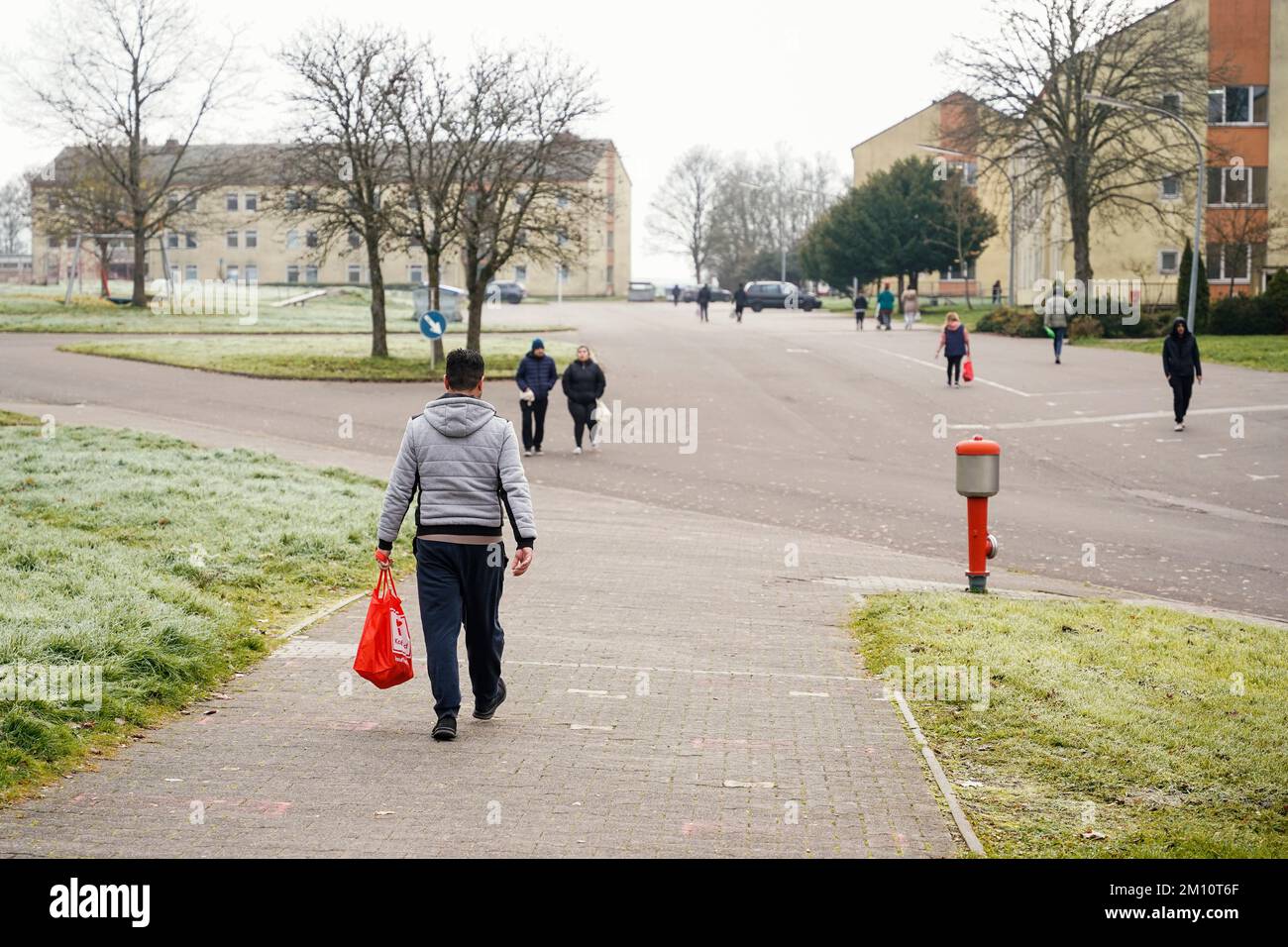 Kusel, Germany. 09th Dec, 2022. Refugees walk past residential ...