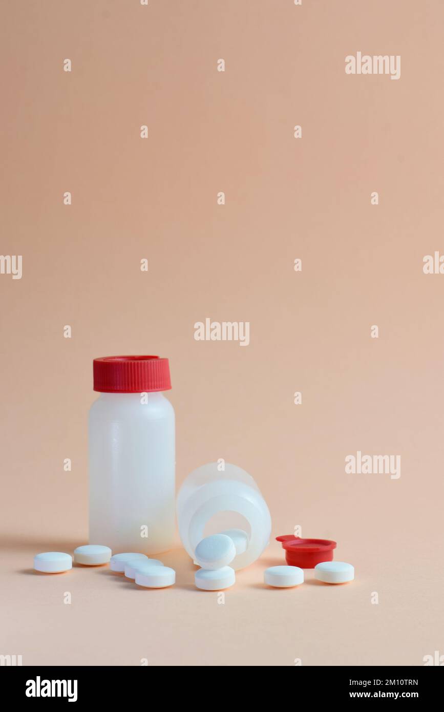 A closeup shot of two bottles of medical tablets, one closed and one ...