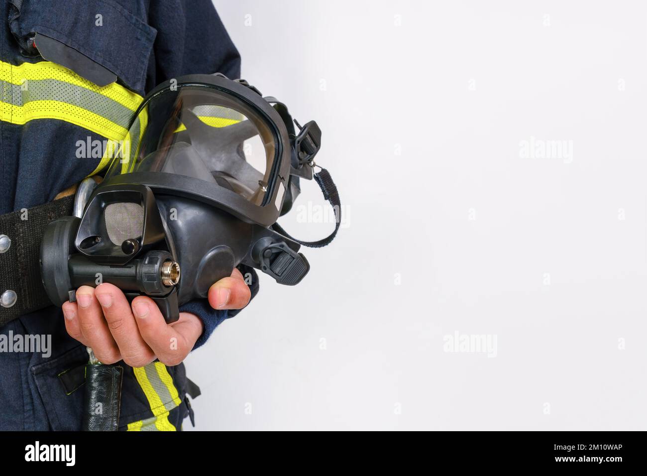 Full protective breathing air mask in hand of unrecognized firefighter ...