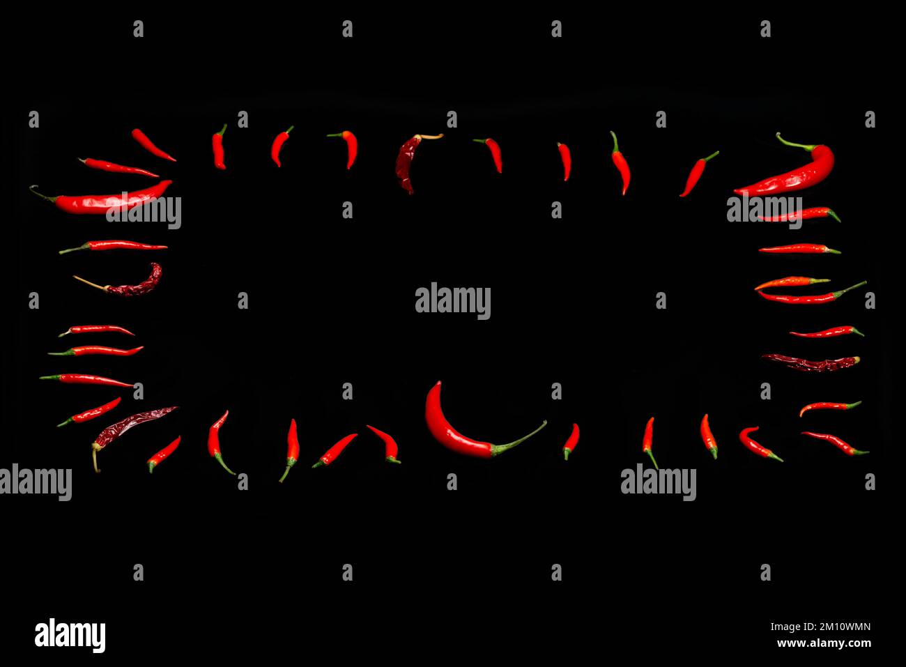 Red chili peppers on a black background Stock Photo - Alamy