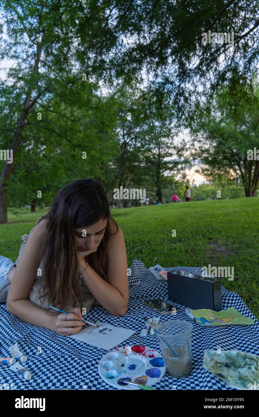 A young beautiful woman drawing a painting outdoors Stock Photo - Alamy