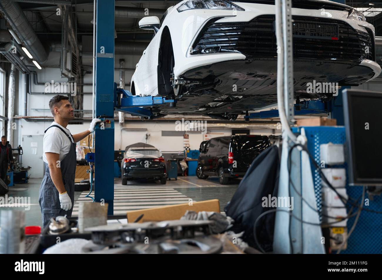 Mechanic working in tire fitting, preparing car for inspection Stock ...