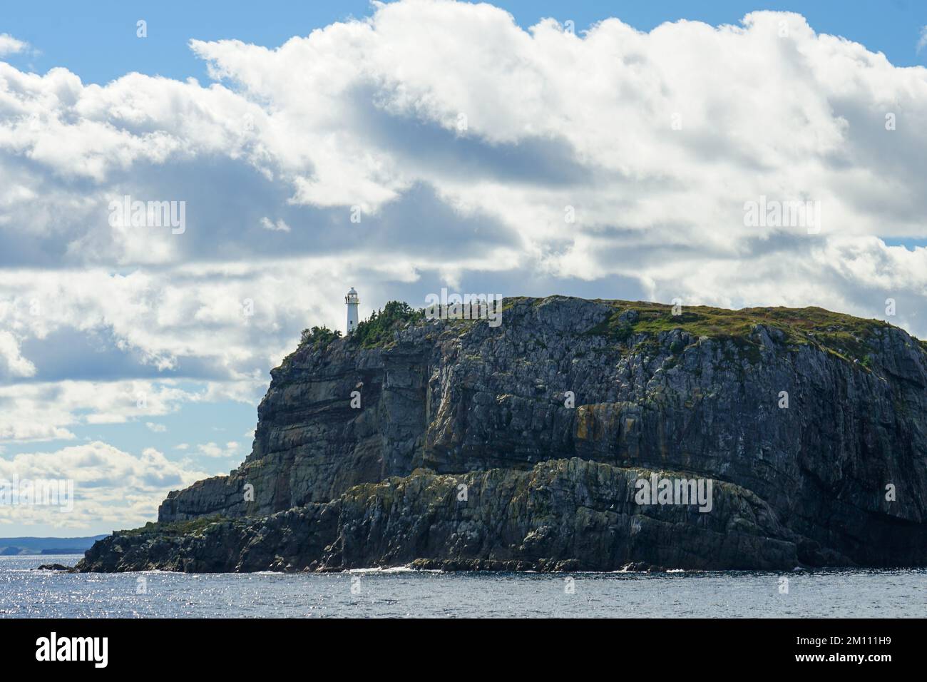 Water-side view of a lighthouse on a dramatic cliff in Newfoundland ...