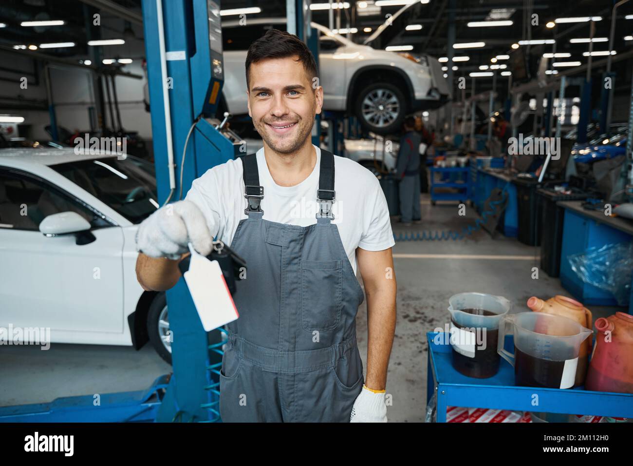 Technician finished repairing car and giving keys Stock Photo - Alamy