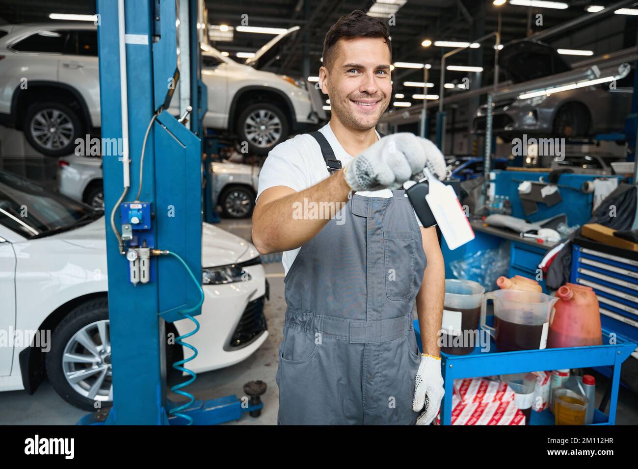 Mechanic finished repairing car and giving keys Stock Photo - Alamy