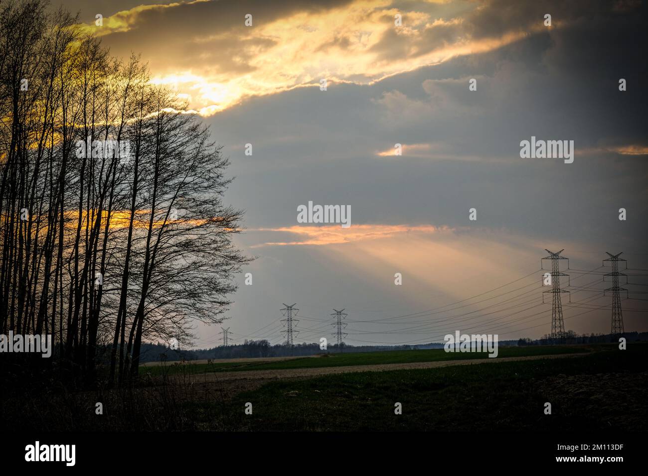 Sunset - rays breaking through the clouds. In the background, the power ...