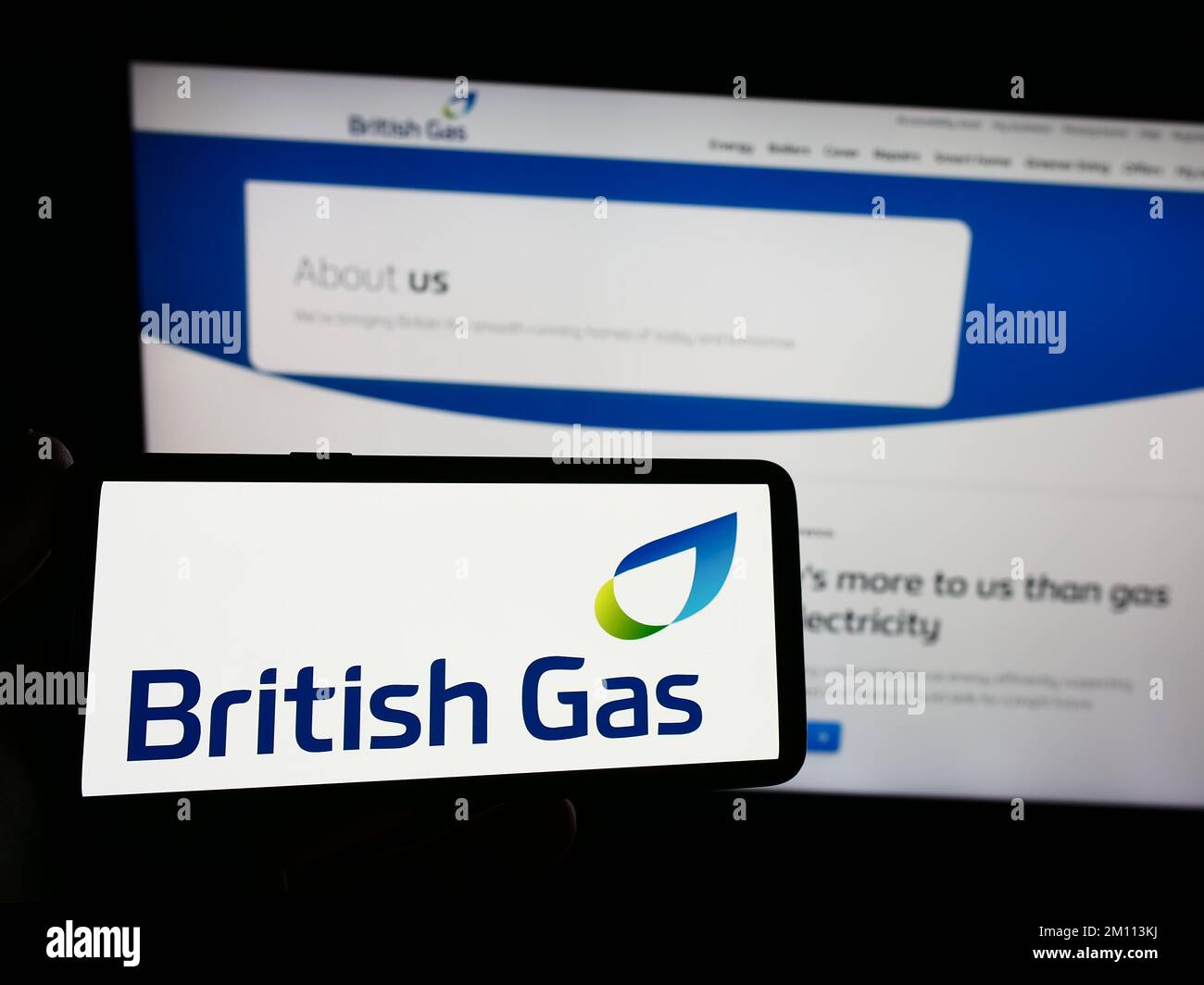 Person holding smartphone with logo of energy company British Gas on screen in front of website ...