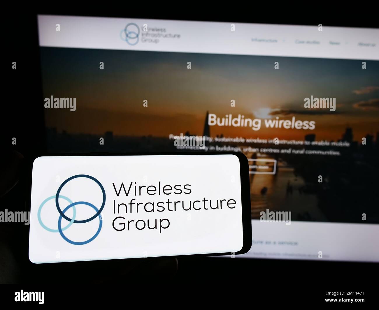 Person holding smartphone with logo of company Wireless Infrastructure ...