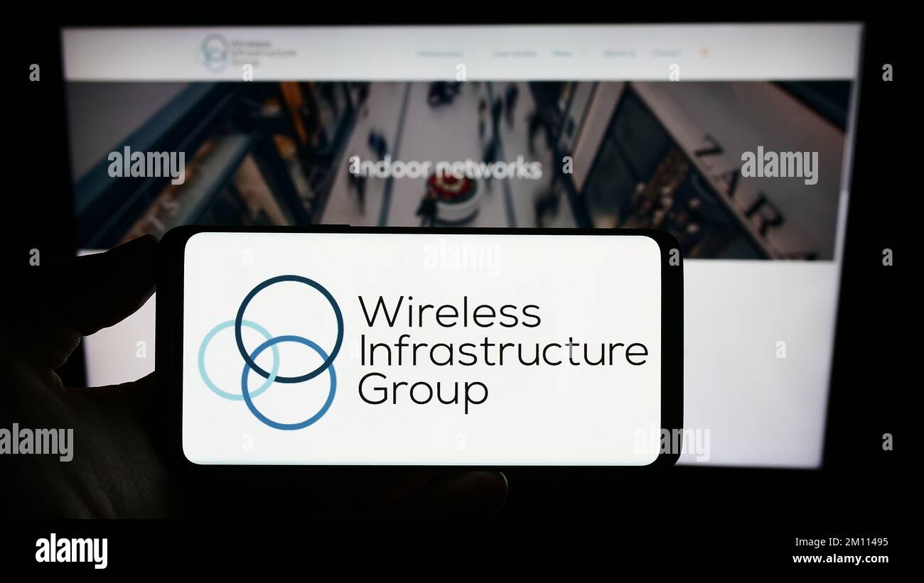 Person holding mobile phone with logo of company Wireless ...