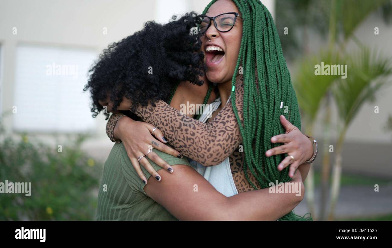 Two happy black women happy reunion embrace. South American latin women ...