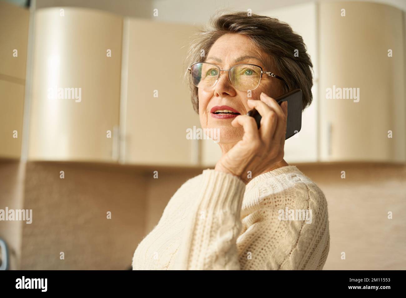 Elderly female calling to family and looking at window Stock Photo - Alamy