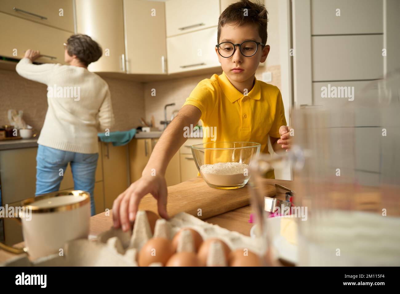 Boy came to visit granny and preparing pastries Stock Photo - Alamy