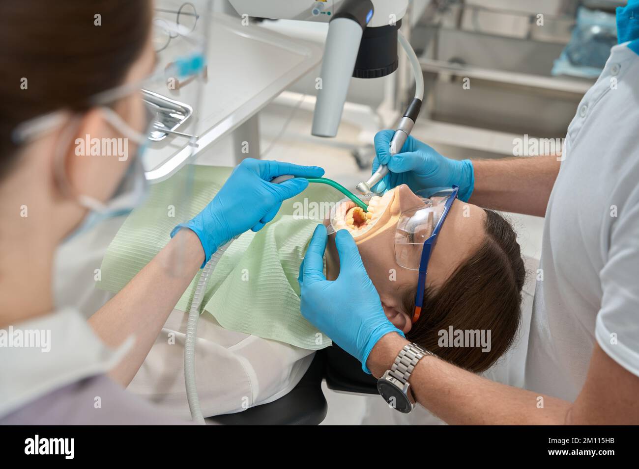 Experienced doctor conducting dental calculus removal under microscope ...