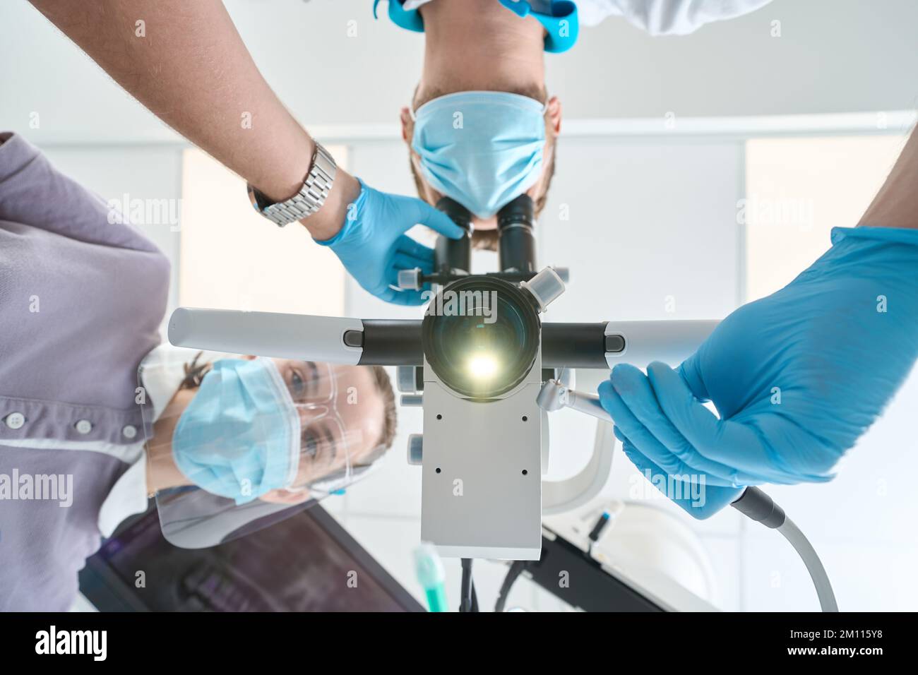Dentist performing teeth treatment using optical instrument assisted by ...