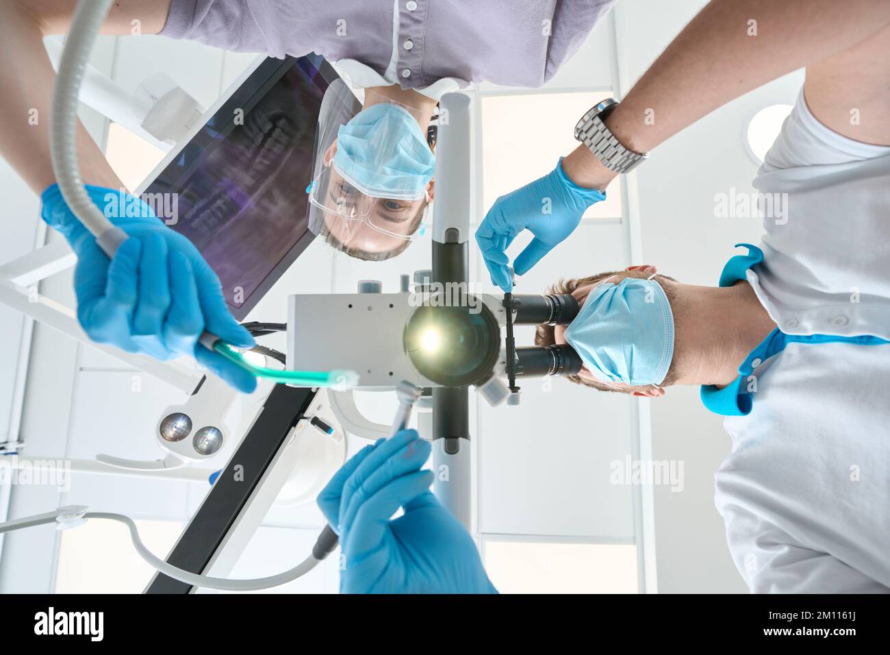 Dentist performing treatment procedure assisted by female nurse Stock ...