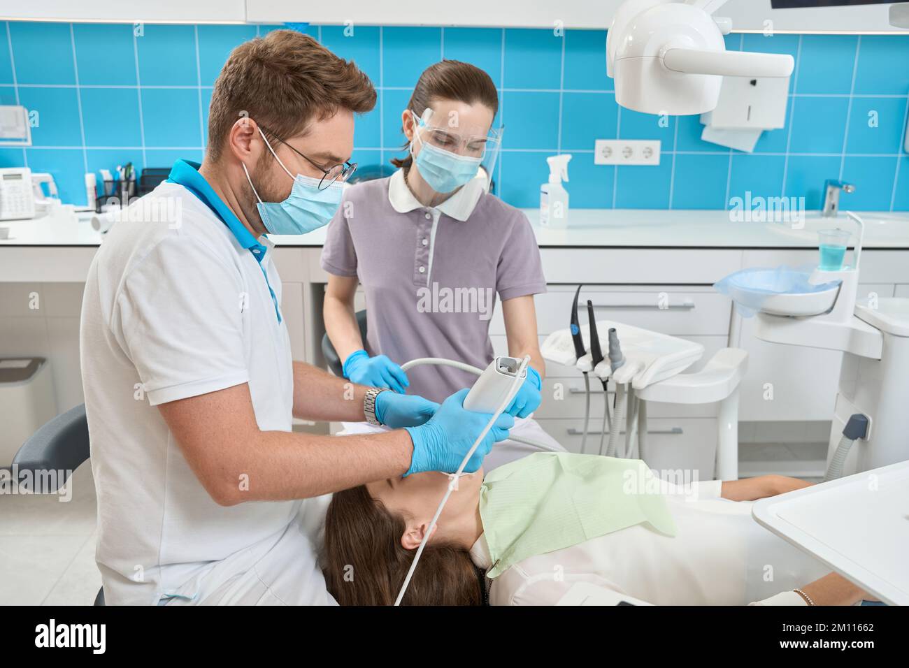 Male dentist performing teeth examination hi-res stock photography and ...