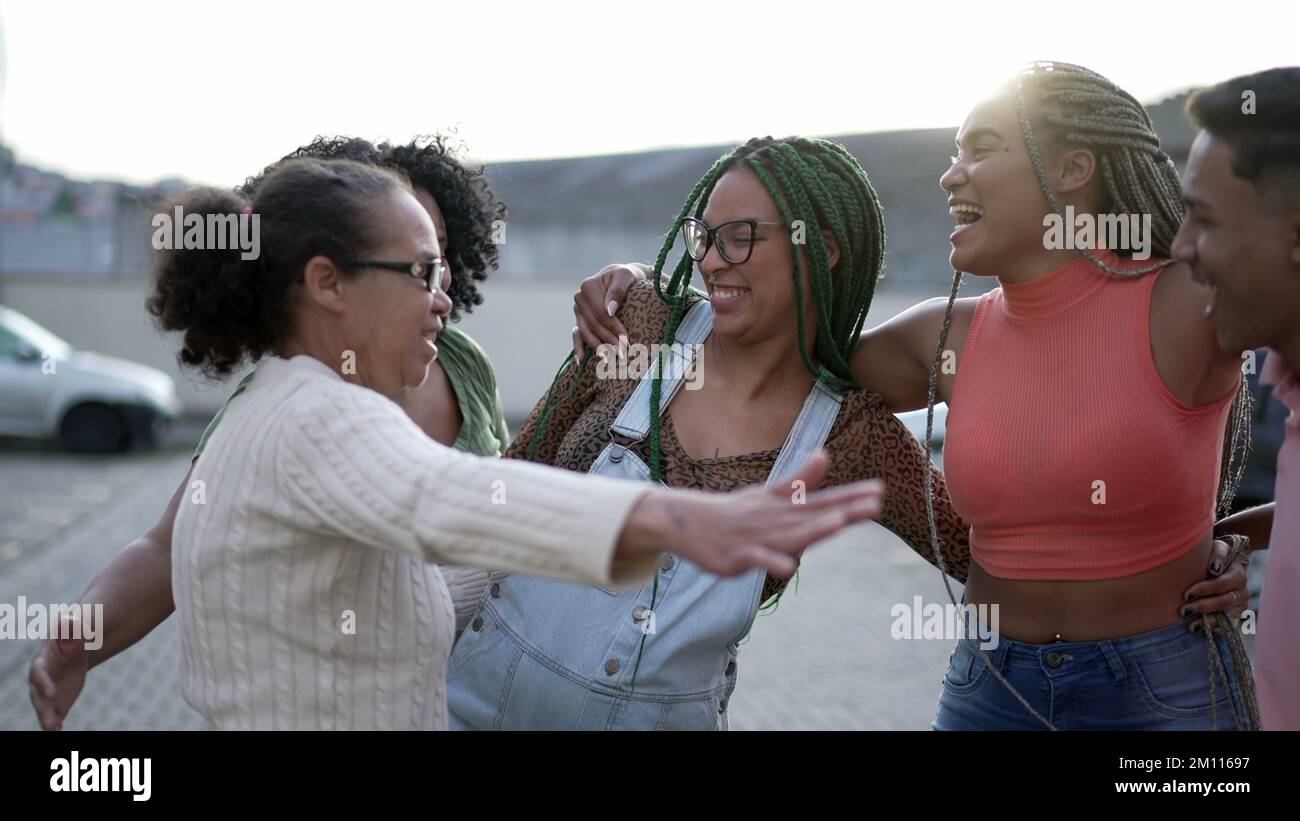 A black family embrace. Group of South American hispanic people hugging ...