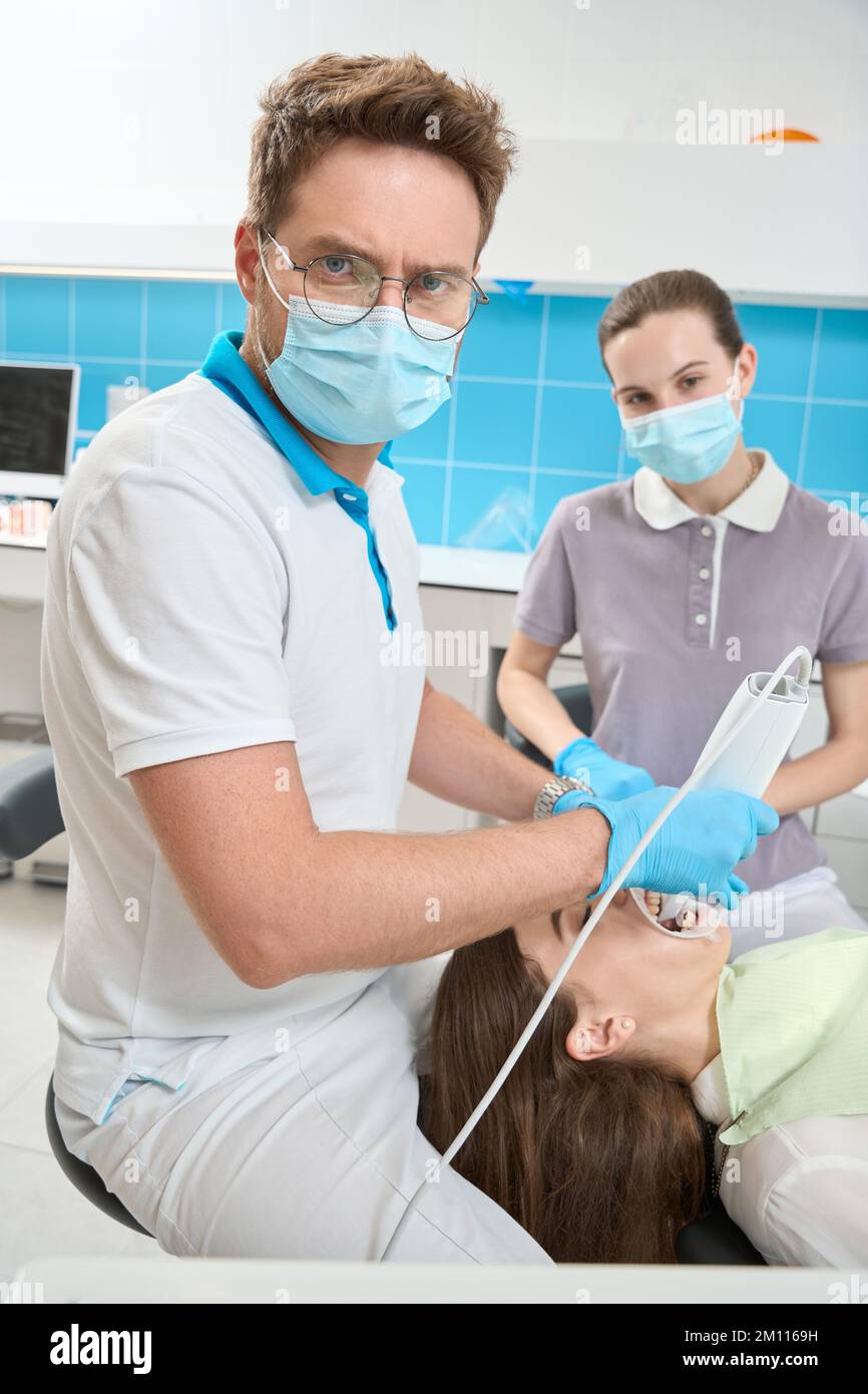 Stomatologist inspecting patient teeth using diagnostic equipment Stock ...