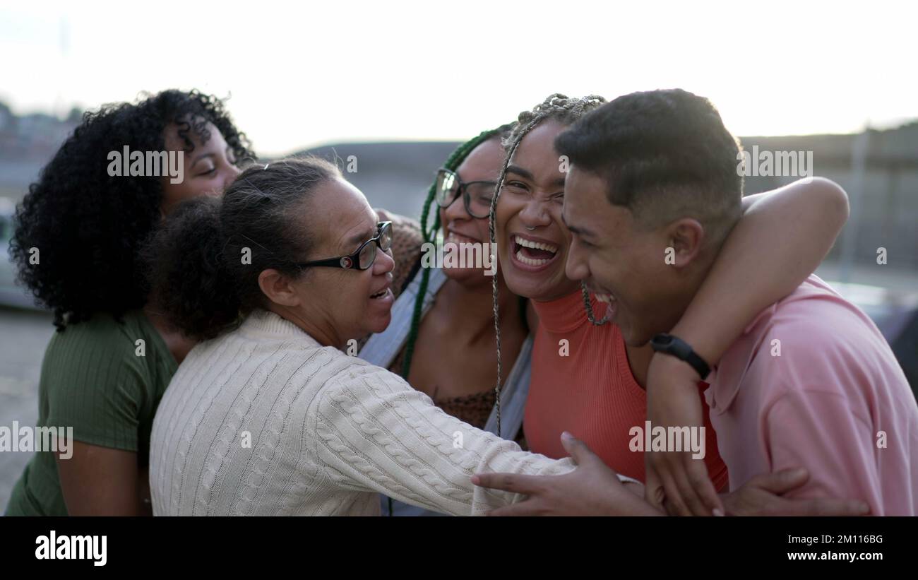 A black family embrace. Group of South American hispanic people hugging ...